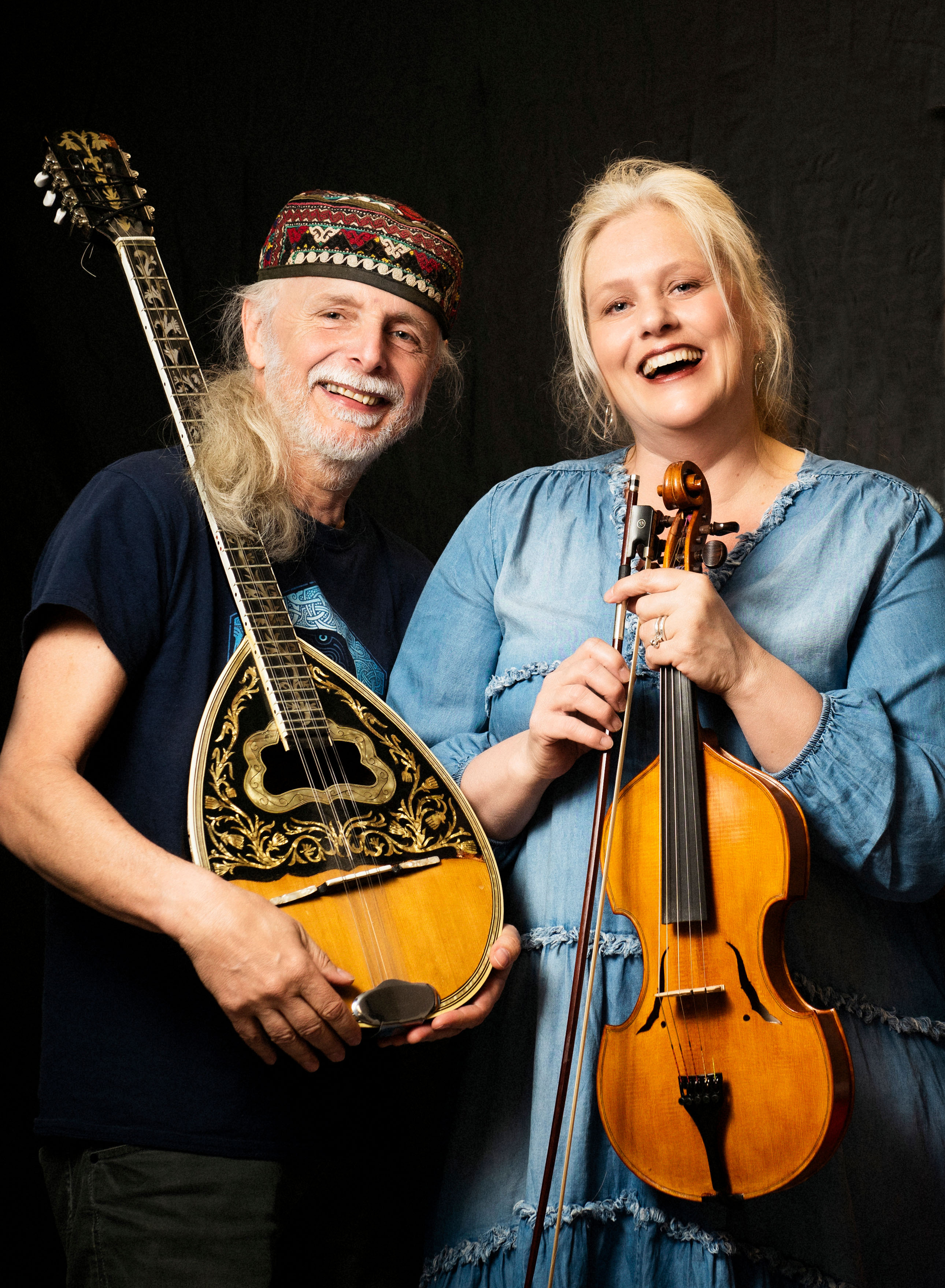 En man och en kvinna. Mannen håller i stränginstrument bouzouki ...